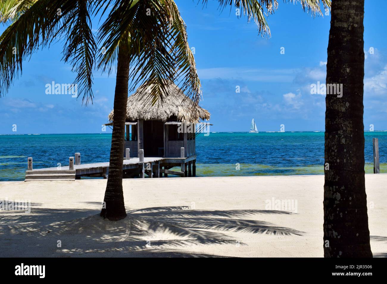 A little palapa at a beach resort, over blue water, on a sunny day on ...