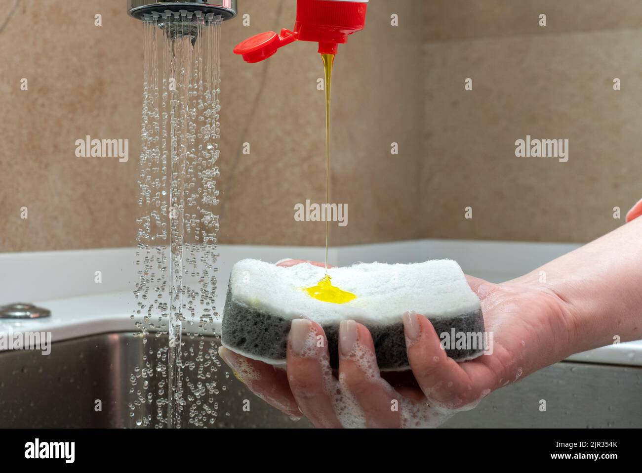 Detergent flows onto the sponge from top to bottom before washing ...