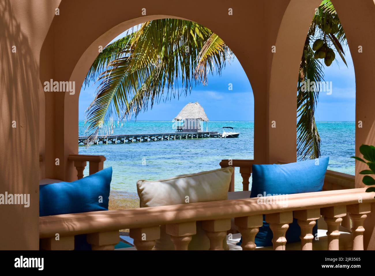 Tropical view of a palapa at the end of a pier over the water as seen ...