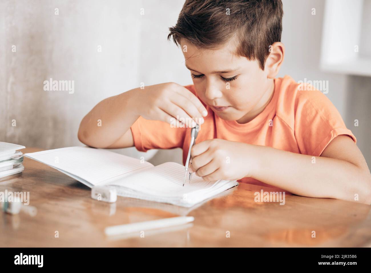 Little school boy doing homework with spring divider, sitting at the ...