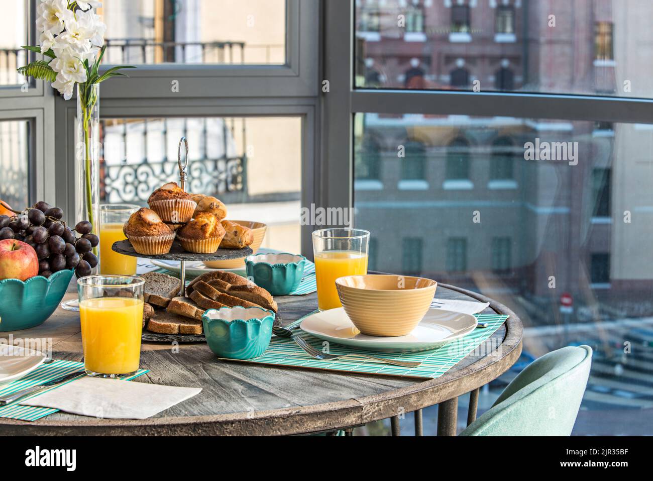 Breakfast service with blue porcelain crockery, glasses with orange ...