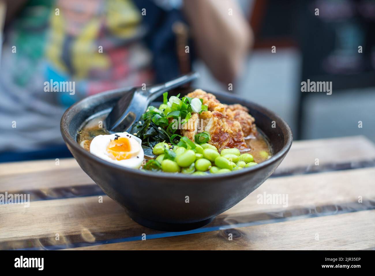 A closeup shot of a bowl delicious ramen noodles with fried chicken ...