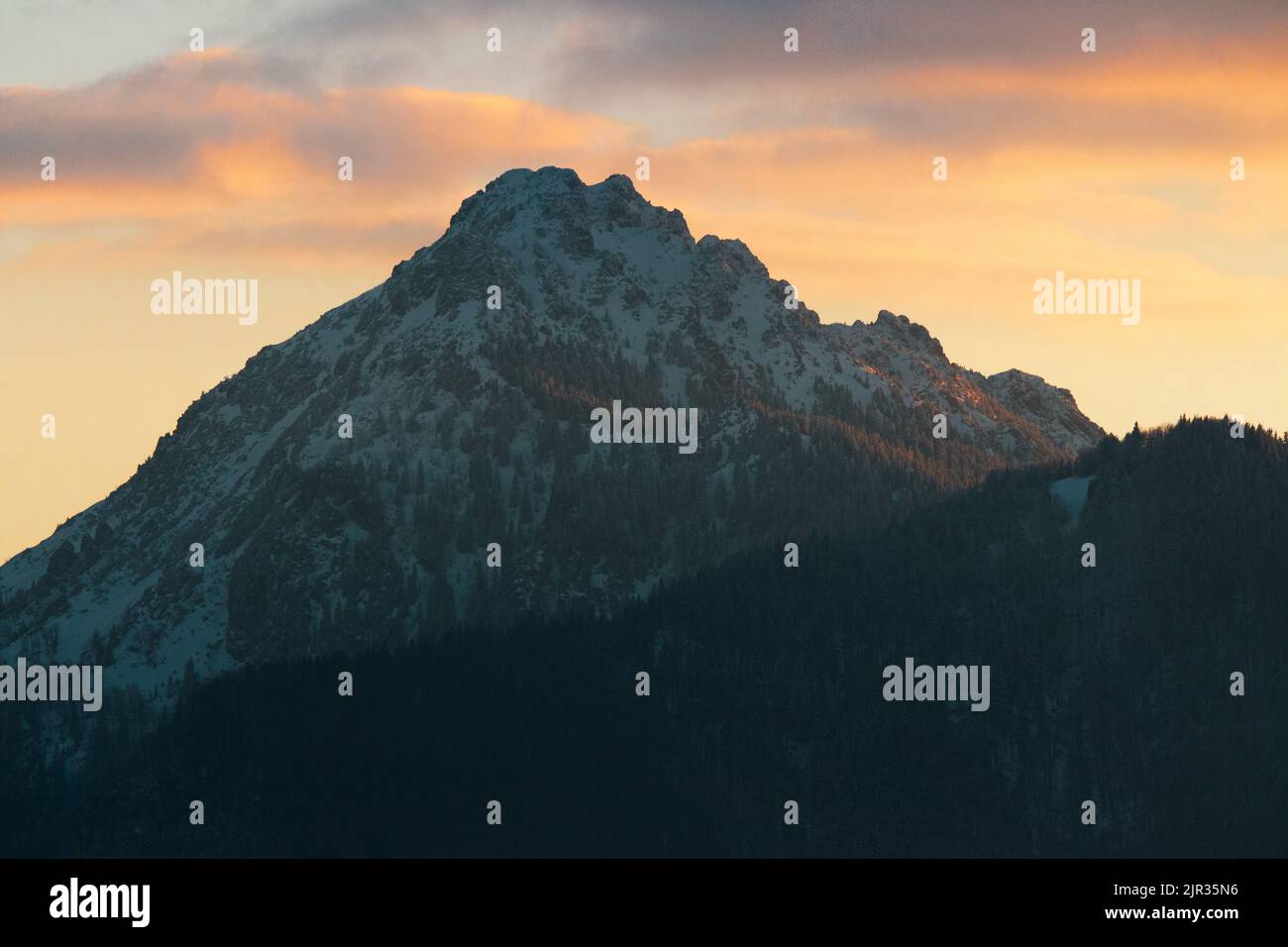 A snowcap mountain against colorful sunset sky background Stock Photo ...