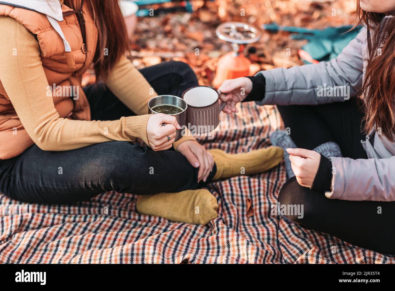 Two girls drinking hot tea from metal cups outdoor, camping Stock Photo ...