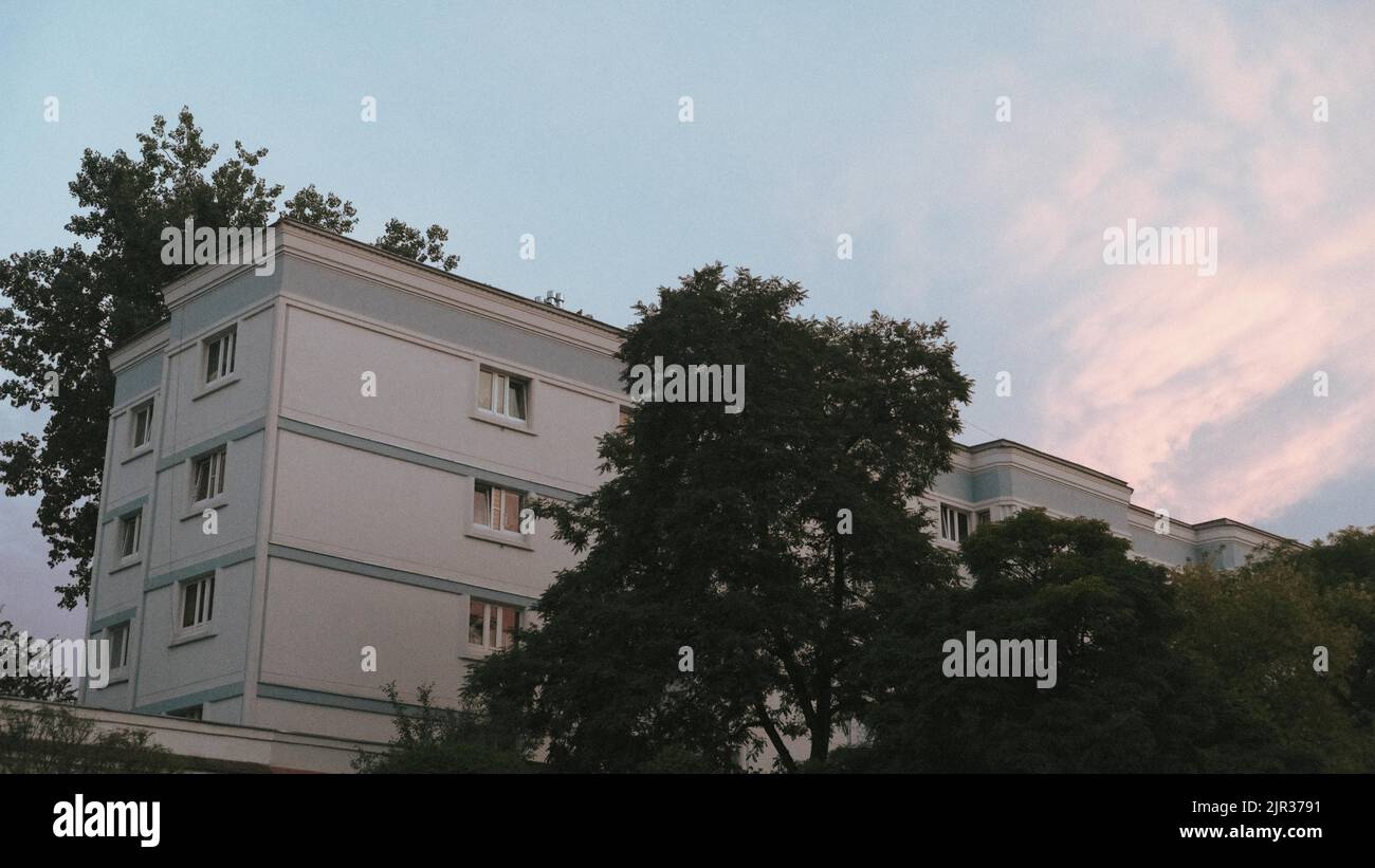 A panoramic shot of a dwelling house with trees front and sky ...