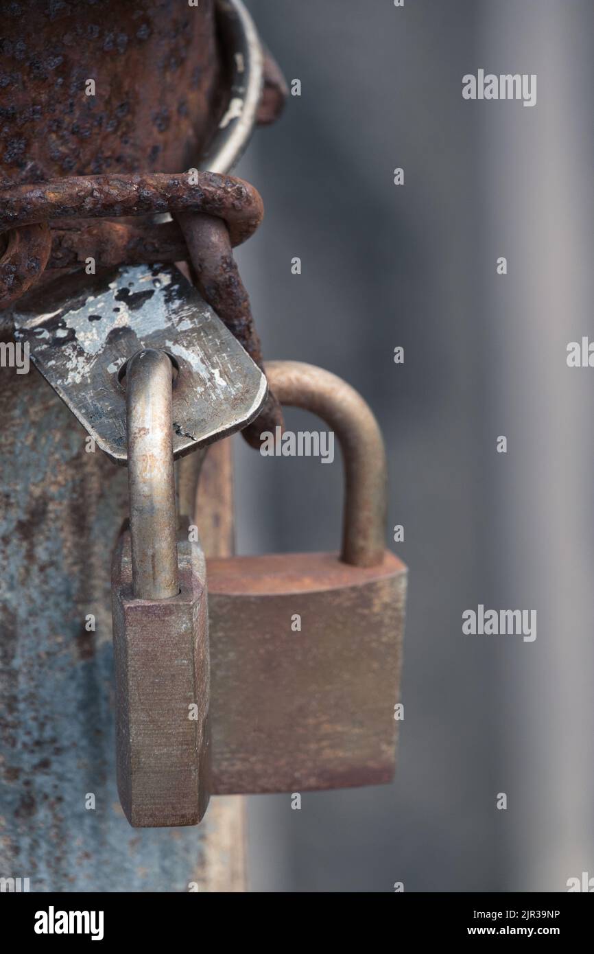 Two locked padlocks and rusty chain Stock Photo - Alamy