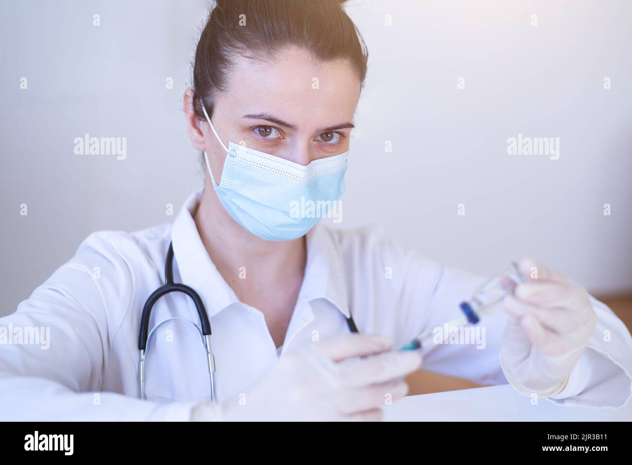 Female doctor preparing syringe. Beautiful nurse preparing a syringe ...