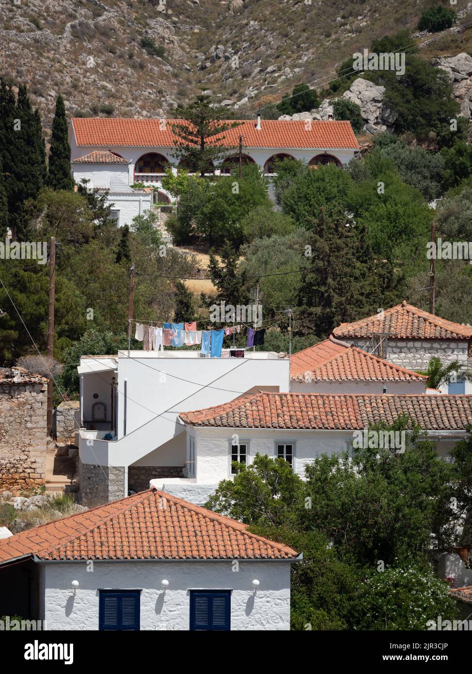 Washing hanging on rooftop of Greek villa surrounded by terracotta ...