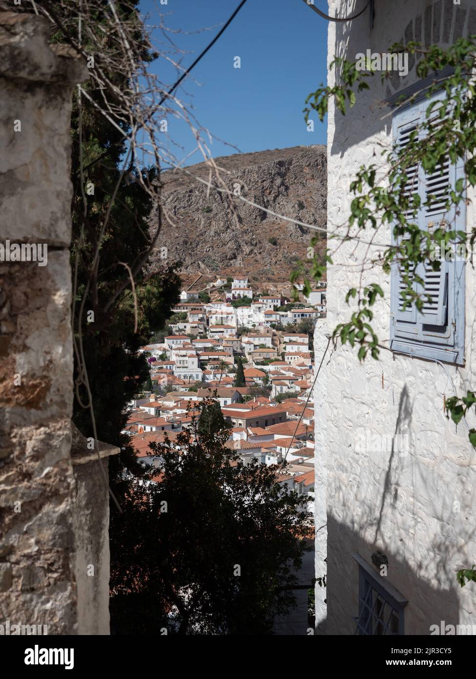 Greek town on Hydra island, terracotta rooftops, mountain and blue ...
