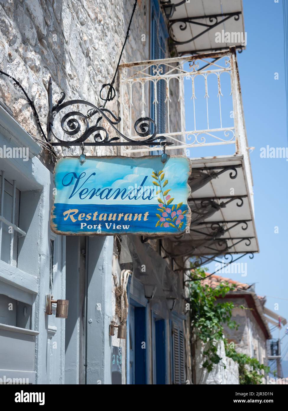 Sign for veranda restaurant with port view below a balcony in Hydra ...