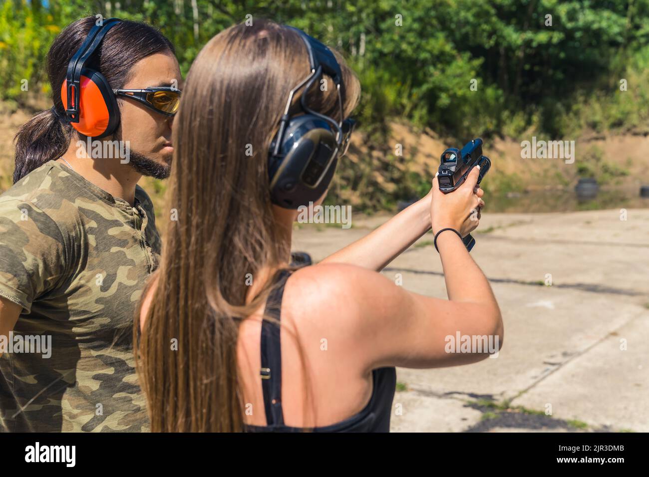 Rear view of white woman and man wearing safety goggles and headphones ...