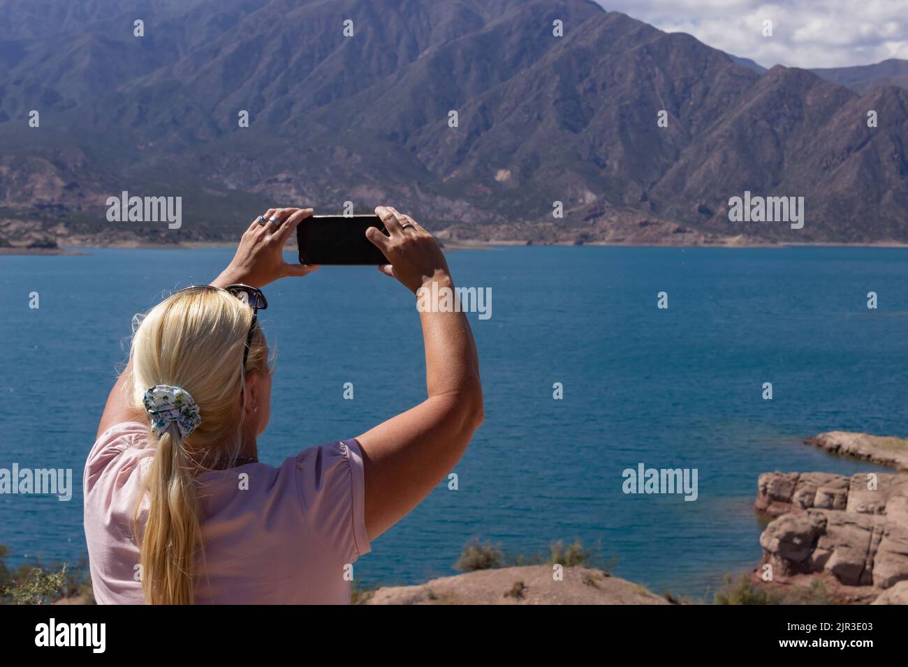 Blonde woman taking a picture in a beautiful scenery Stock Photo - Alamy
