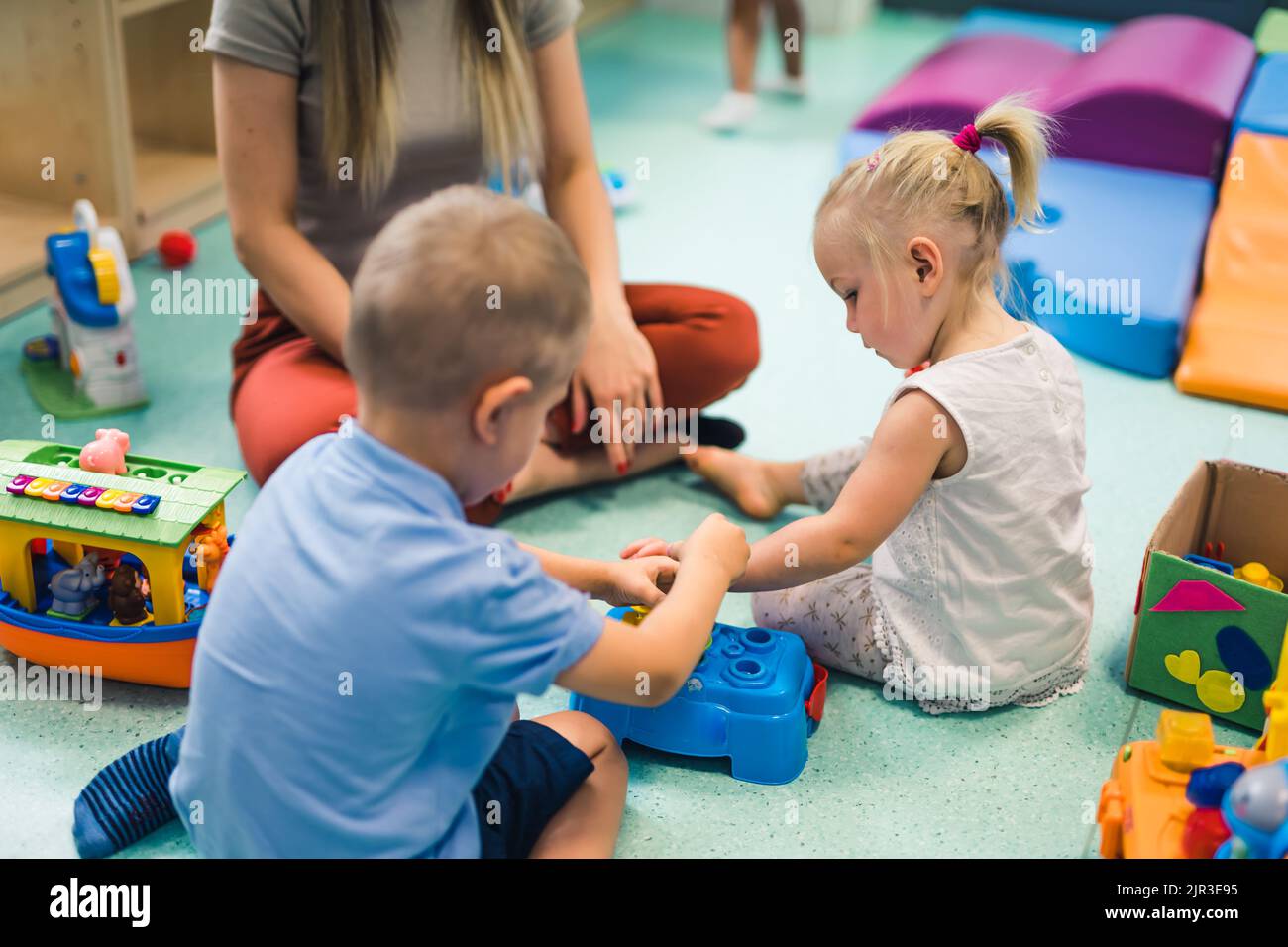 kids building objects with their lovely teacher at the nursery. High ...