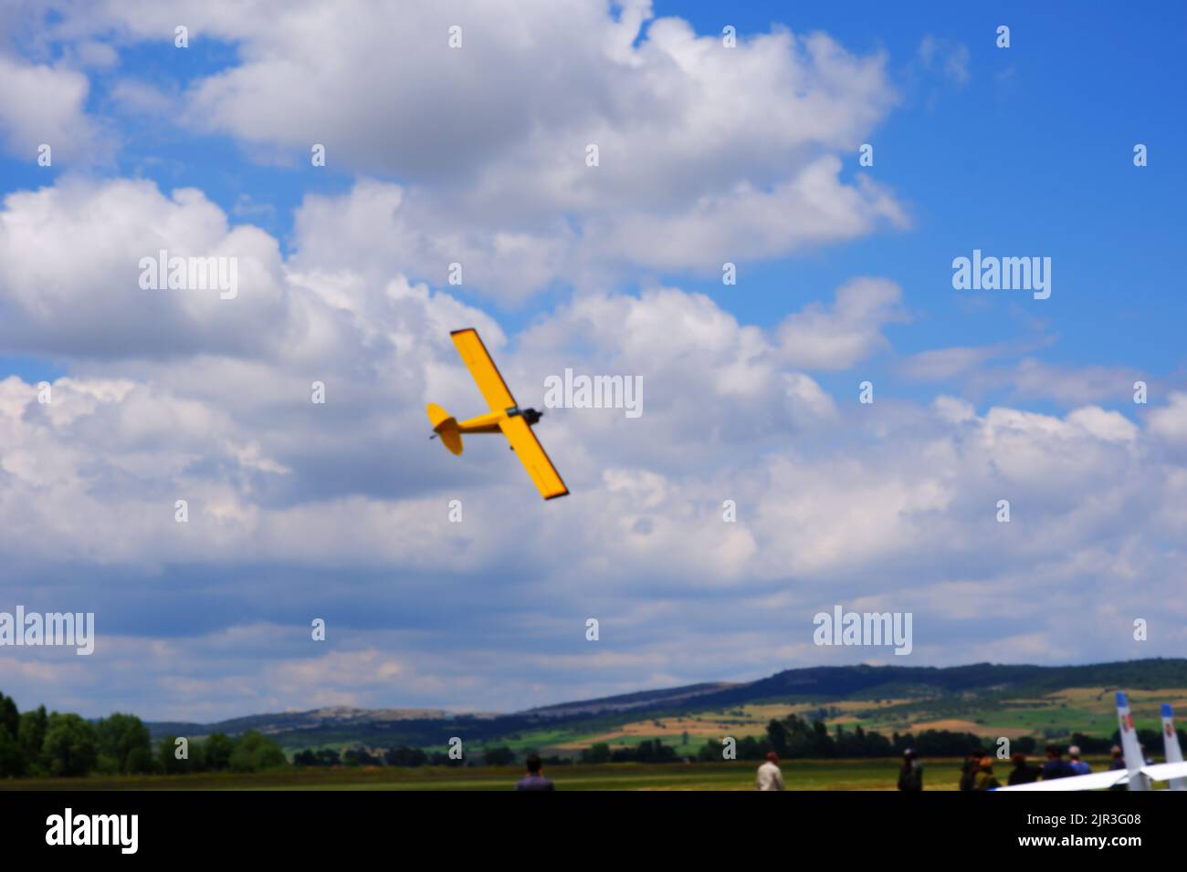 Single engine yellow air plane flying at low altitude close to the ...
