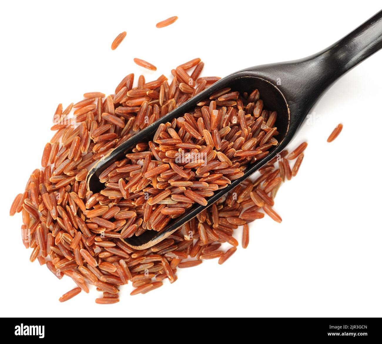 Red raw rice in black wooden spoon, isolated Stock Photo - Alamy