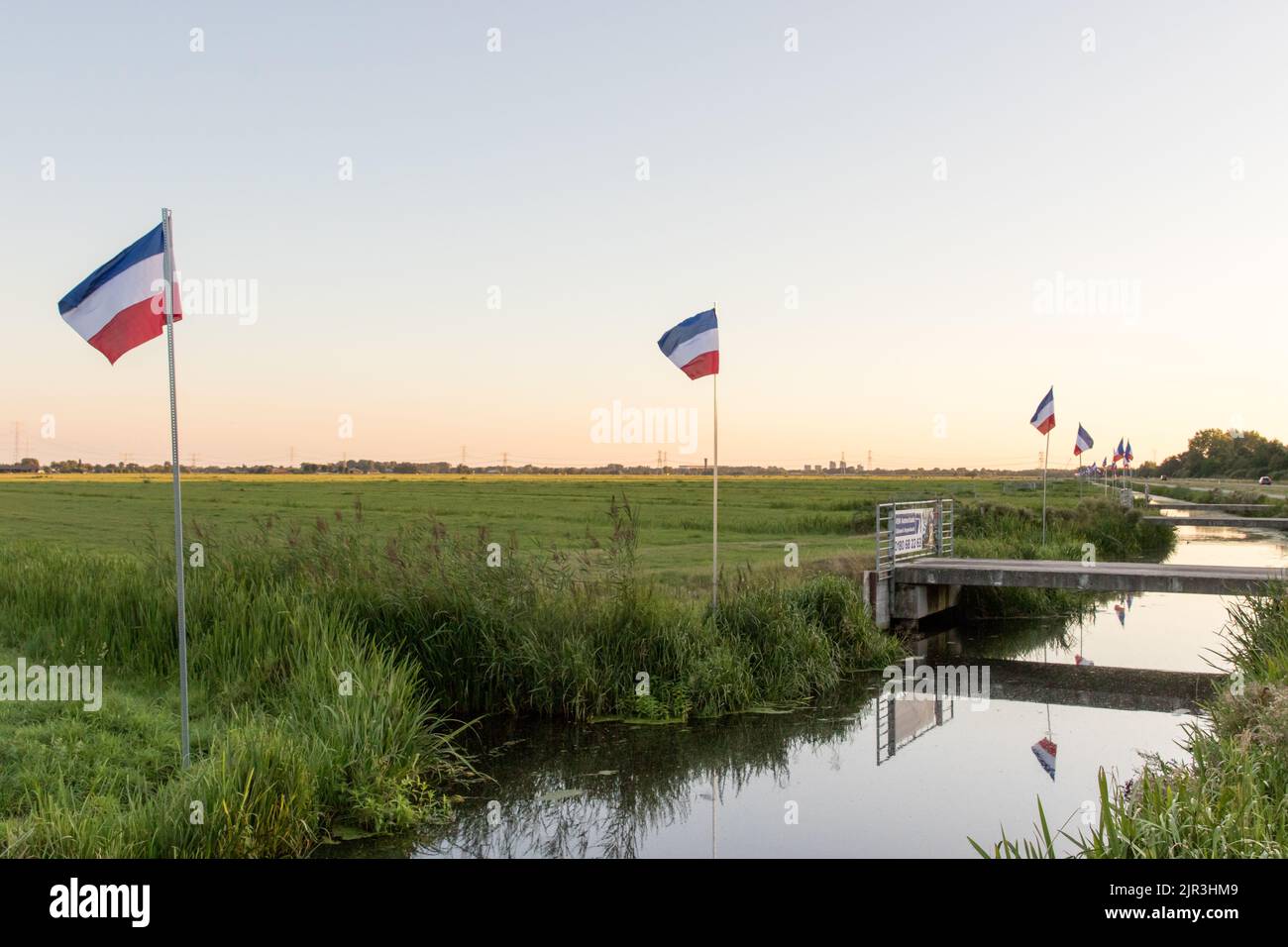 Row of upside down Dutch national flags in farmland as a symbol of ...