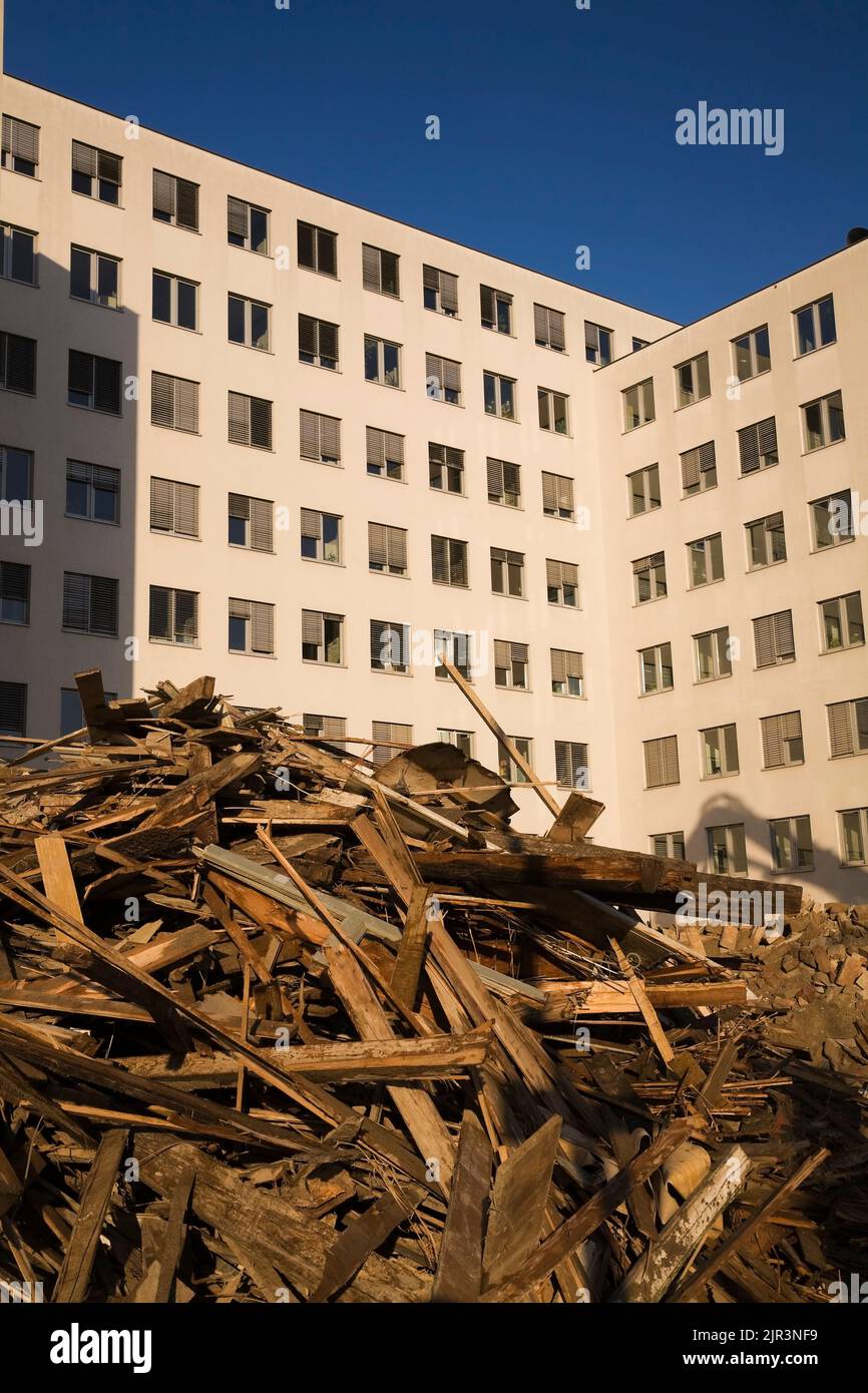 Old and discarded pile of wooden debris in front of a modern ...