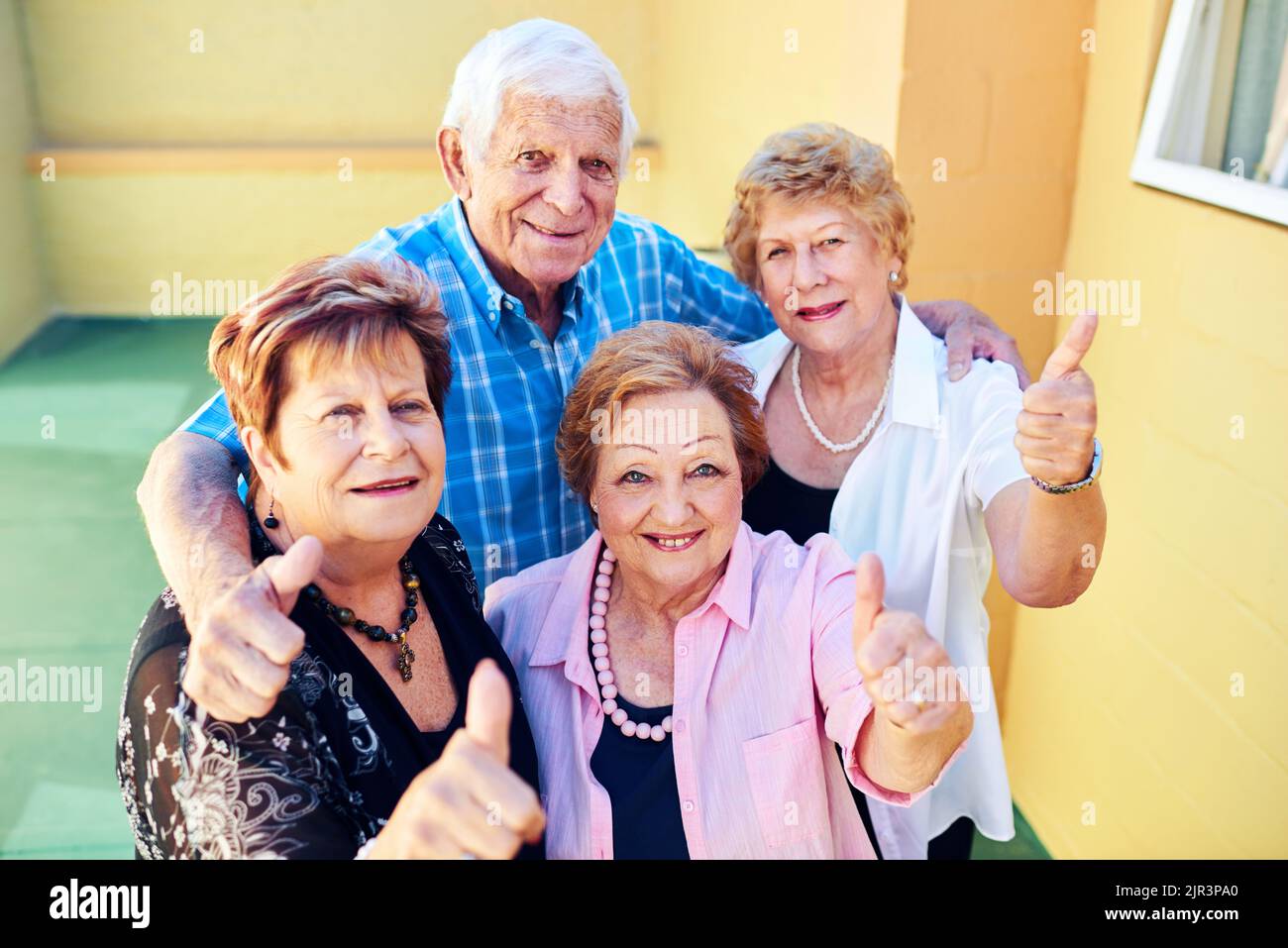 Heres to many more adventures. a group cheerful elderly people smiling ...