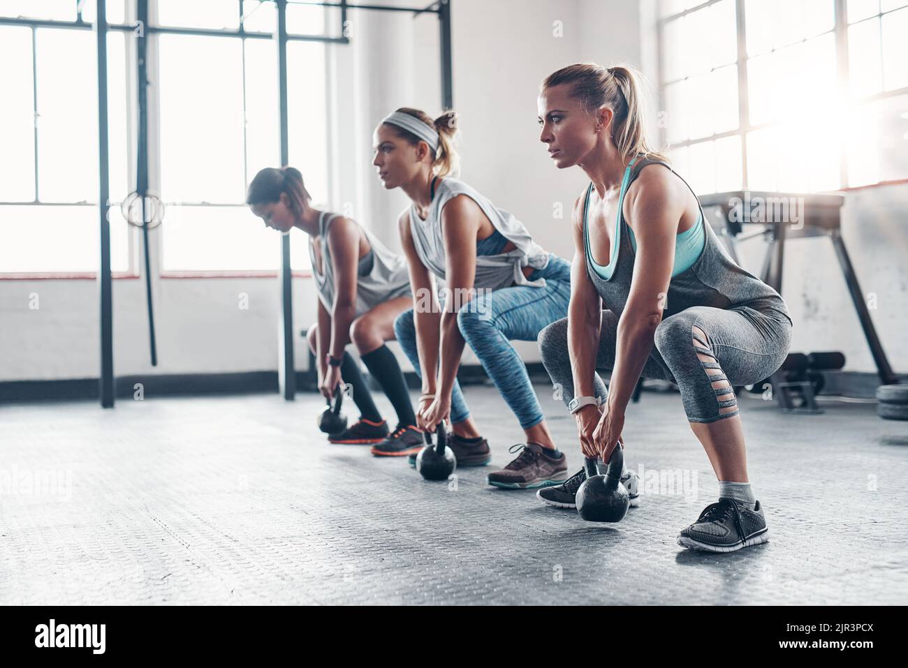 Feel it working in your core. three women working out with weights at ...