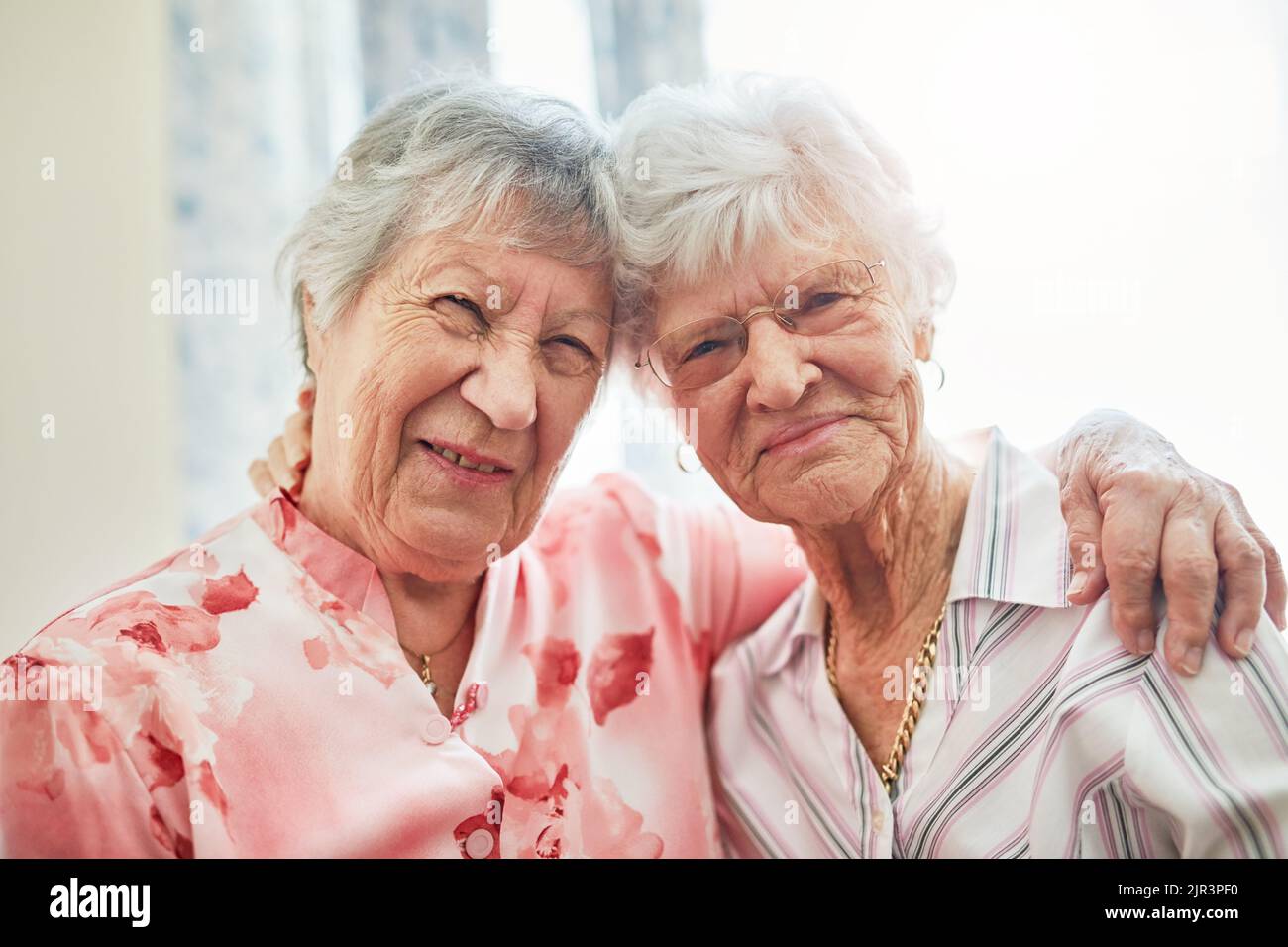 Shes my golden girl. Portrait of two happy elderly women embracing each ...