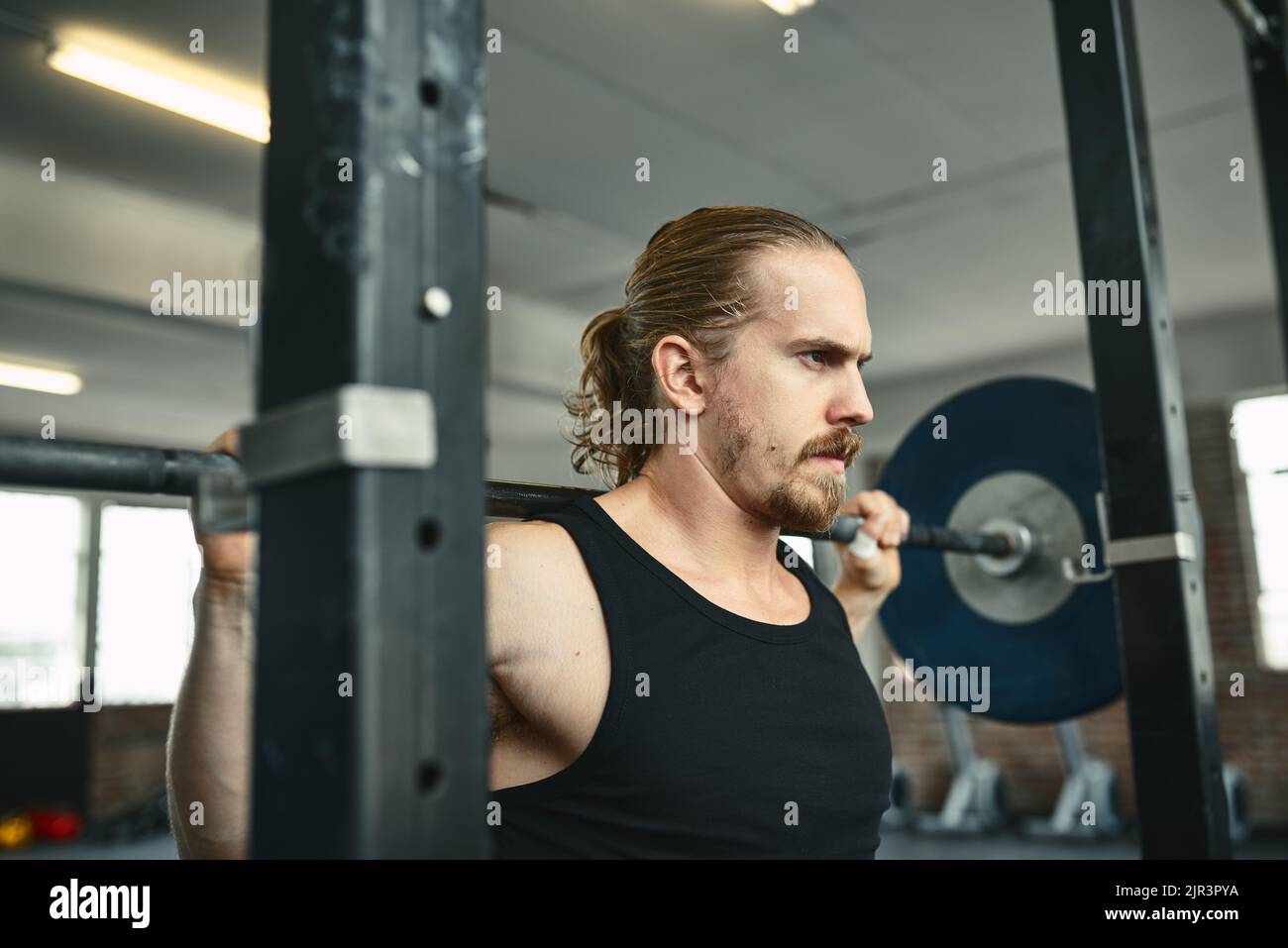 Muscles are built by effort not excuses. a man lifting weights at the ...