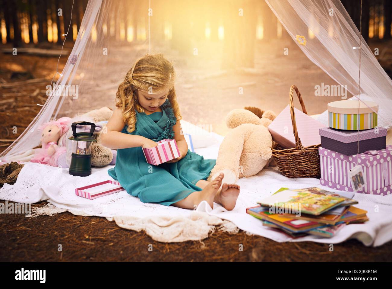 Time to open presents. a happy little girl opening a little box while ...