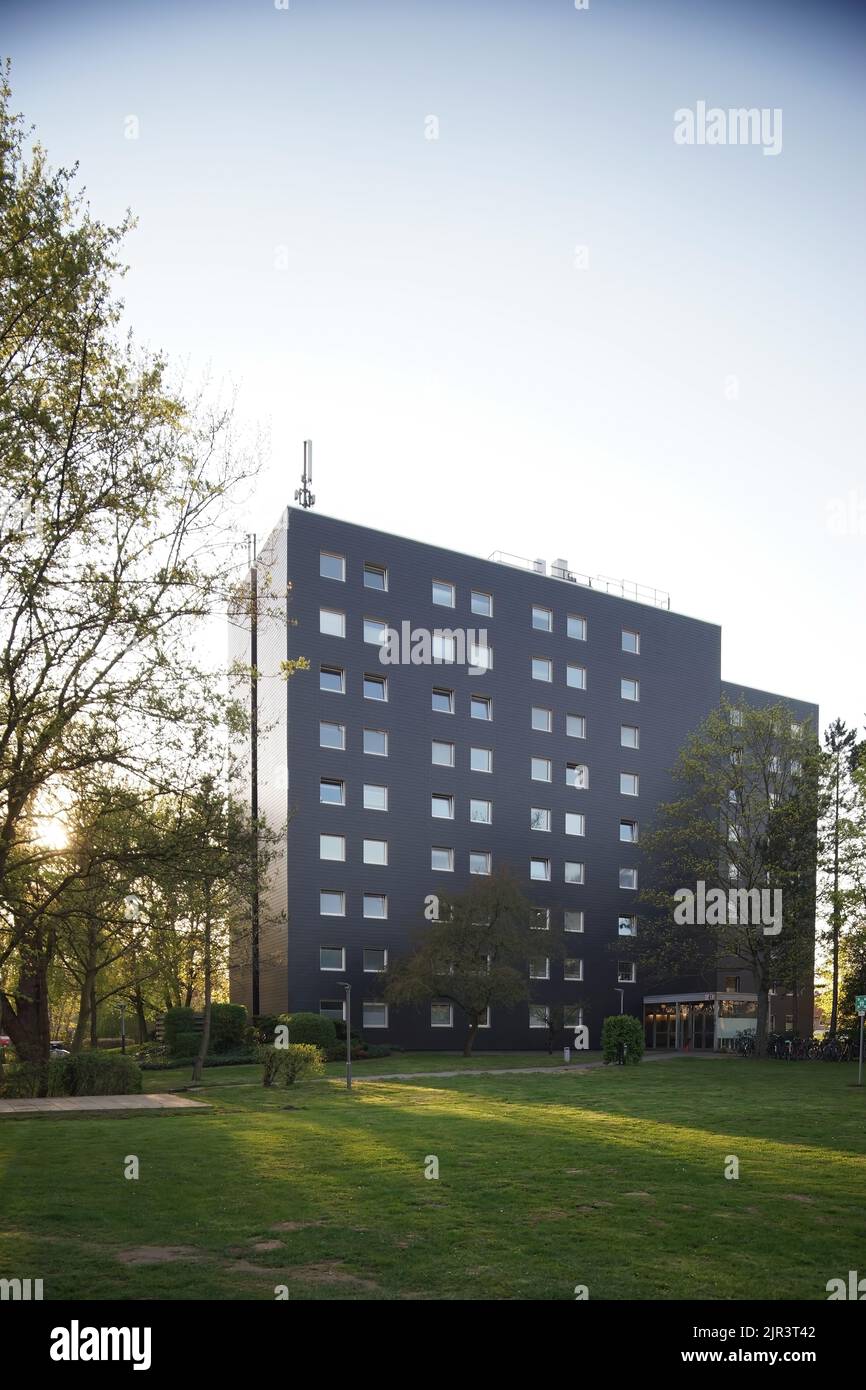 modern building with square windows, facade in dark gray, with sunset ...