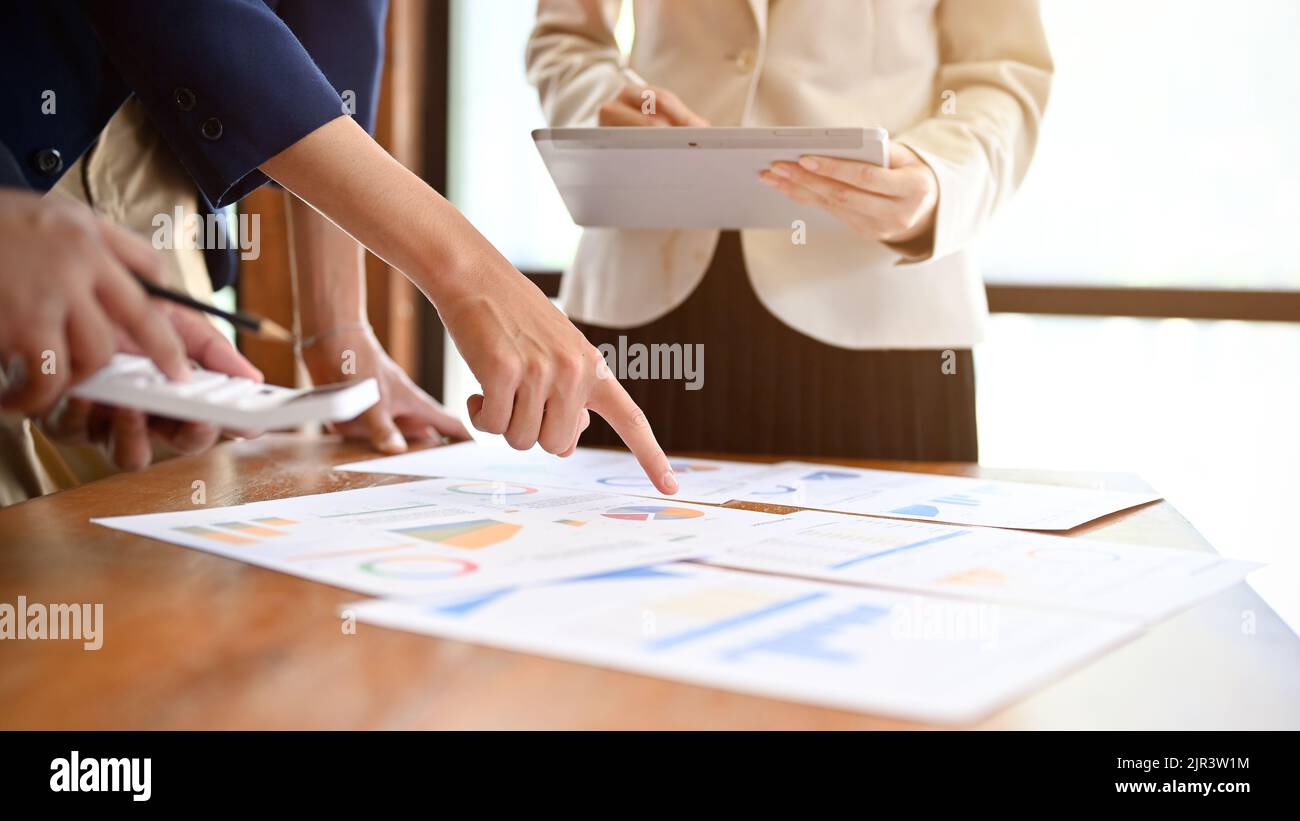 A group of talented businesspeople collaborating on financial tasks in ...