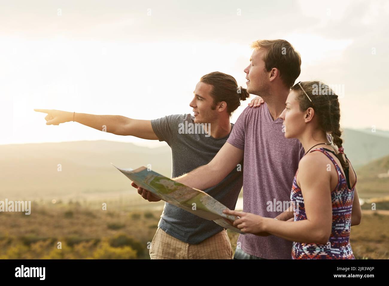 Whats on the other side of that hill. three young hikers consulting a ...