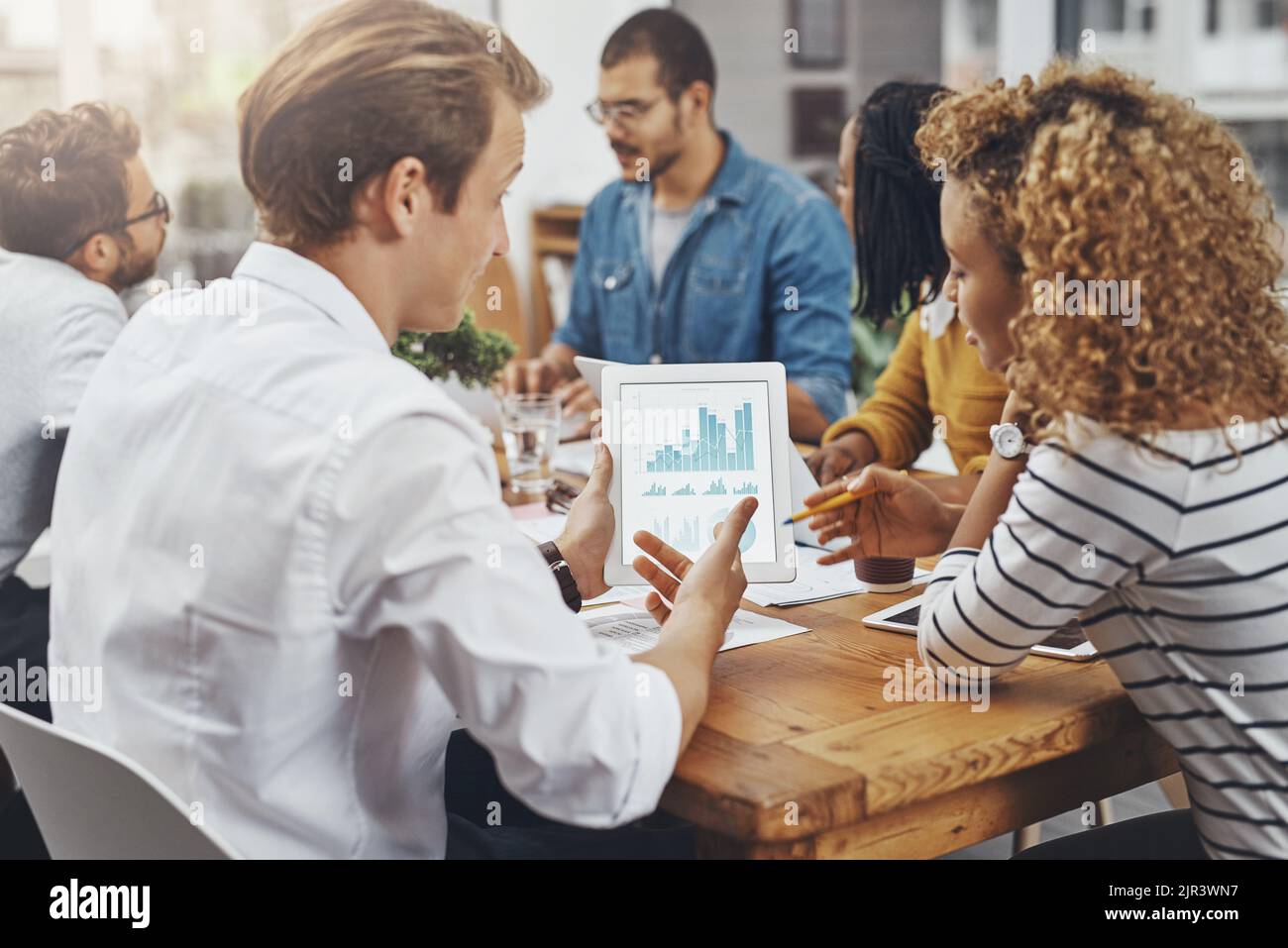 Hes always willing to help. High angle shot of colleagues discussing ...