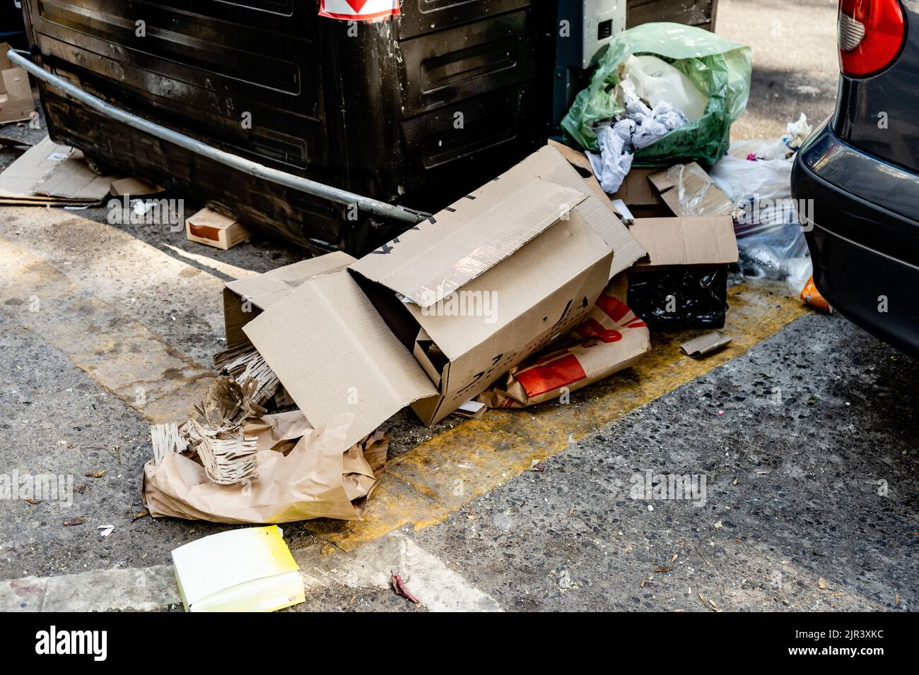 A Garbage dumped on the street next to a street waste container Stock ...