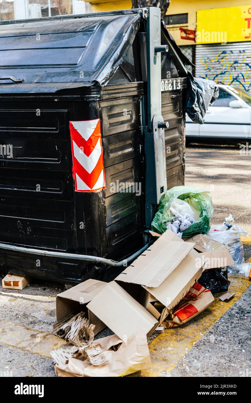 A Garbage dumped on the street next to a street waste container Stock ...