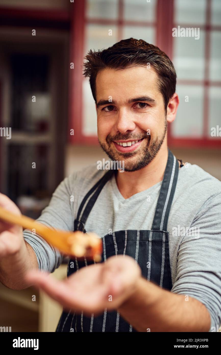 I need a second opinion. a young man cooking in the kitchen Stock Photo ...