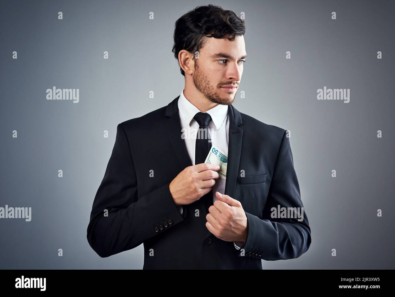 Making money without morals. Studio shot of a young businessman ...