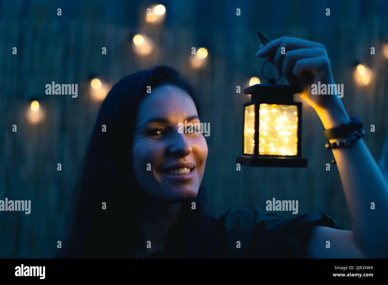 An attractive woman with a retro flashlight at dusk. Front view Stock ...