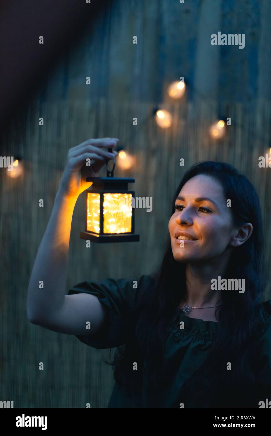 An attractive woman with a retro flashlight at dusk. Vertical photo ...