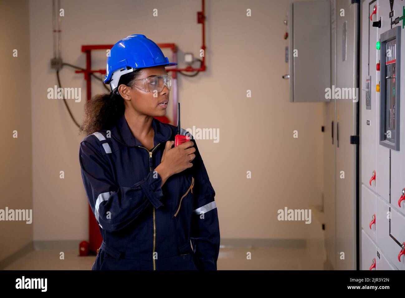 Electrical young asian woman engineer examining maintenance cabinet ...
