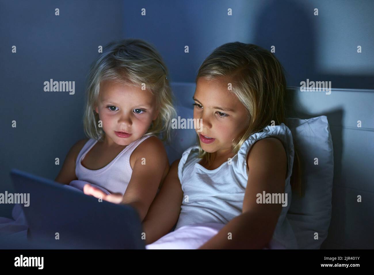Playing on their favourite apps. two little girls using a digital ...