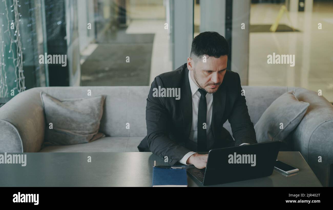 Respected Caucasian businessman in black business suit sitting and ...