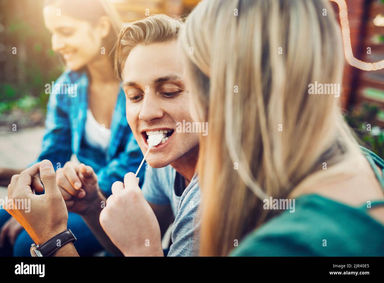 Sweet Memories Together A Young Cheerful Man Being Fed A Marshmallow