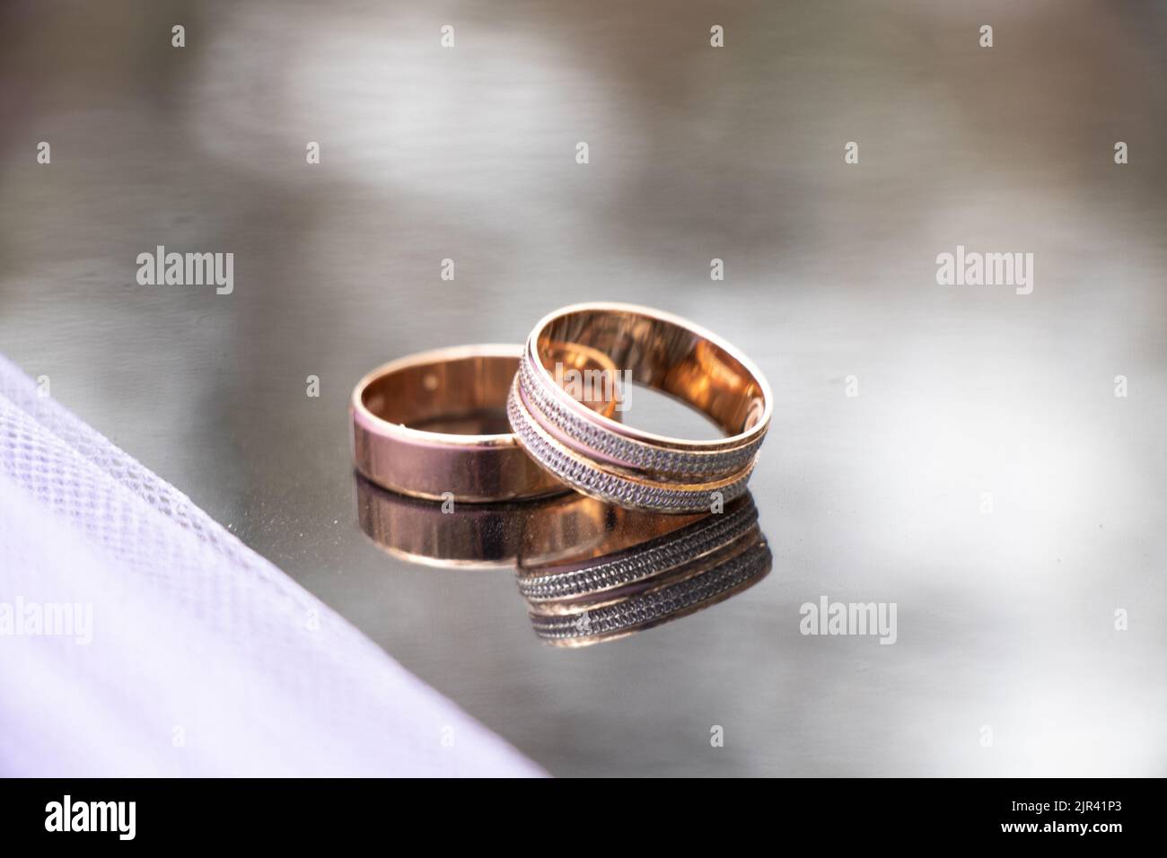 two wedding gold rings on a dark mirror background, wedding gold rings ...