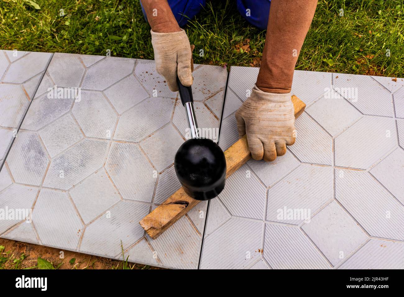 the hands of a professional worker hit the slab with a special rubber ...