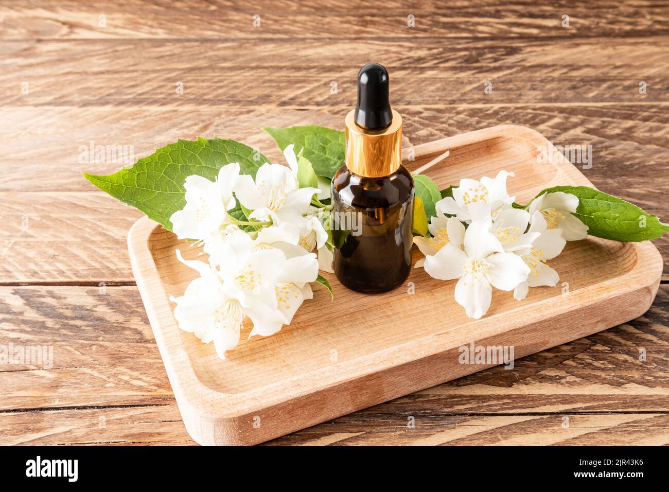 cosmetic bottle with a serum of jasmine flowers or oil for facial skin ...
