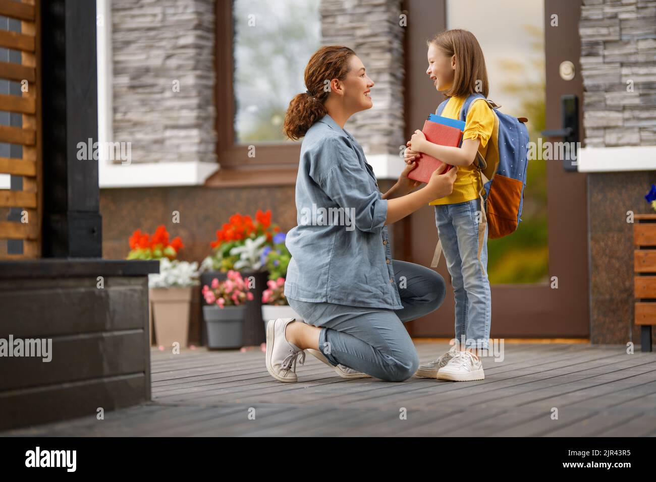 Parent and pupil of primary school going hand in hand. Woman and girl ...