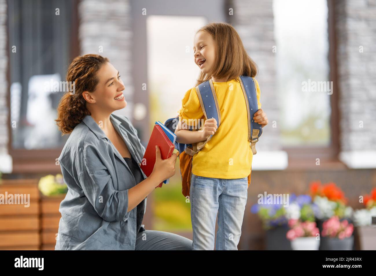 Parent and pupil of primary school going hand in hand. Woman and girl ...