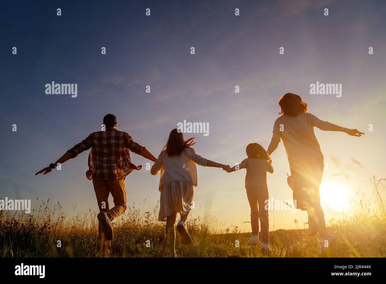 Happy family in the park. Father, mother and children are running ...