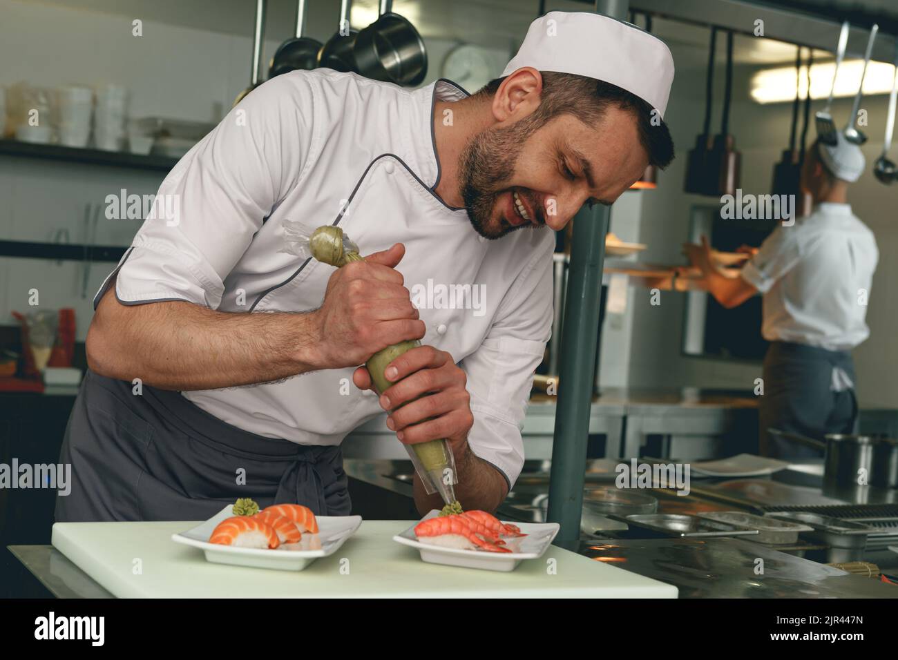 Sushi master prepares sushi for serving in modern commercial kitchen ...