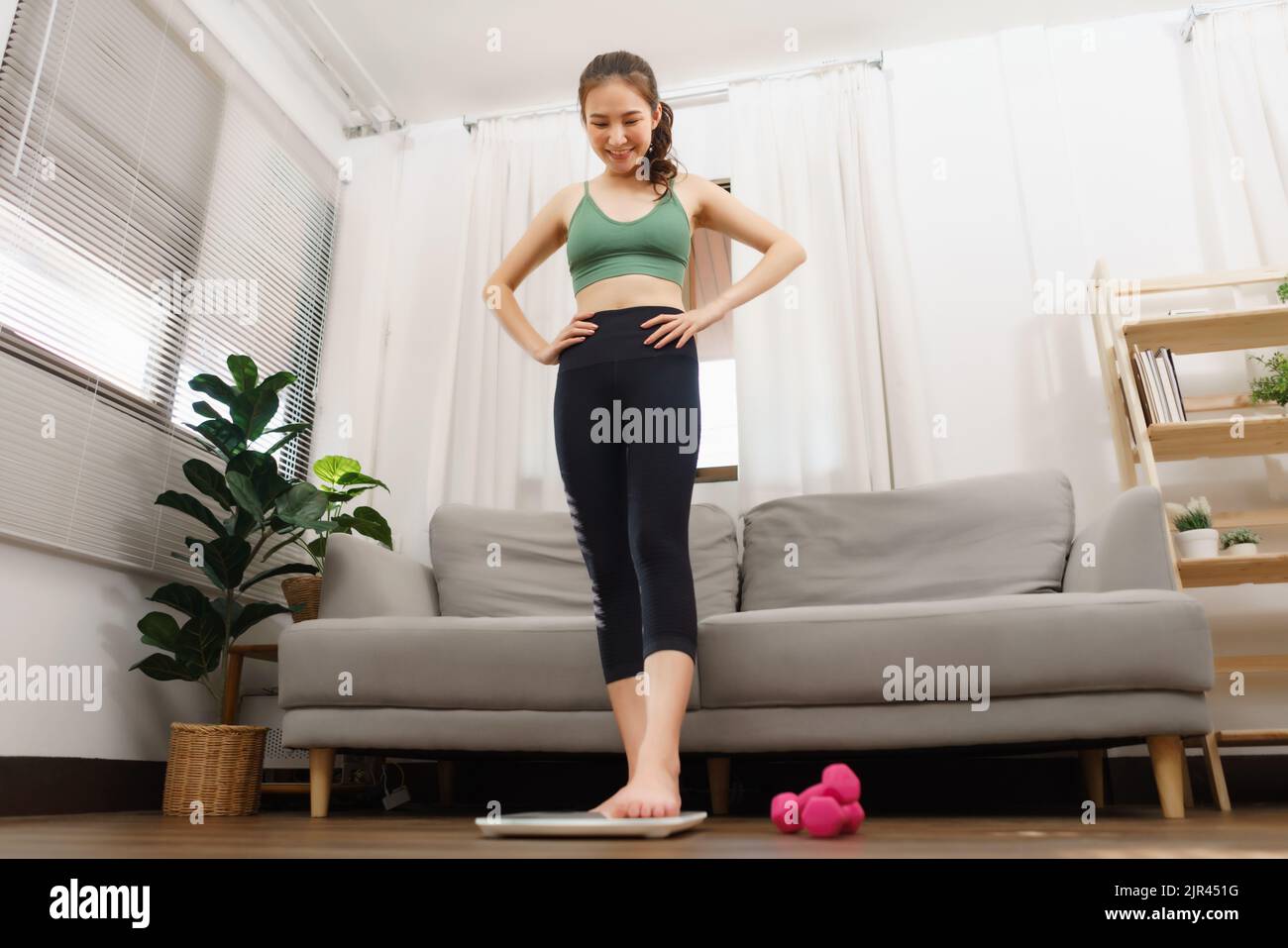 Healthy and weight loss concept, Young Asian woman stepping on weighing ...