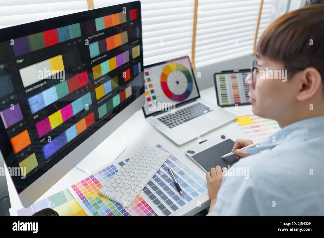 Creativity concept, Male graphic designer using tablet and looking ...