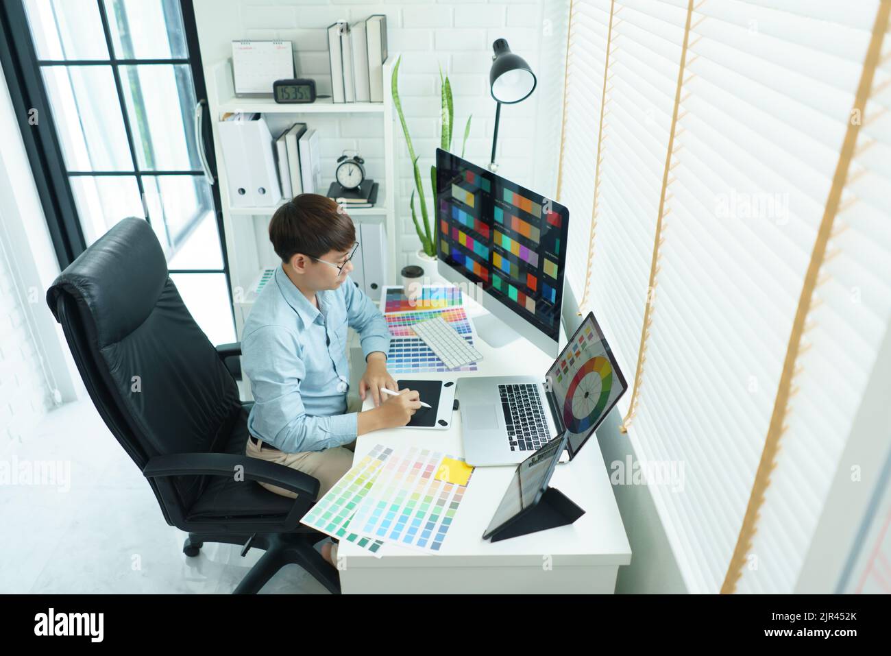 Creativity concept, Male graphic designer using tablet and looking ...